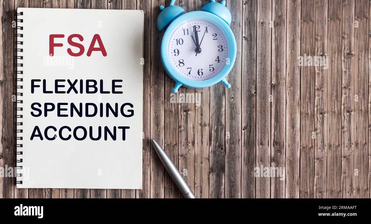 FSA flexible expense account sign on notepad and wooden background ...