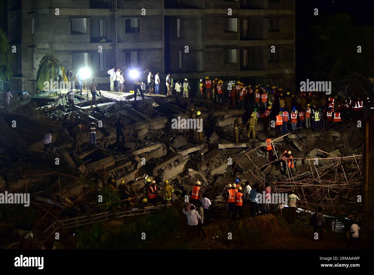 Rescuers search for workers buried in the rubbles of a building that ...