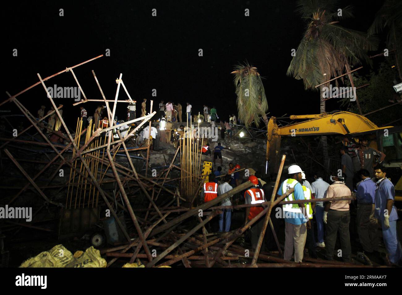 Rescuers search for workers buried in the rubbles of a building that ...