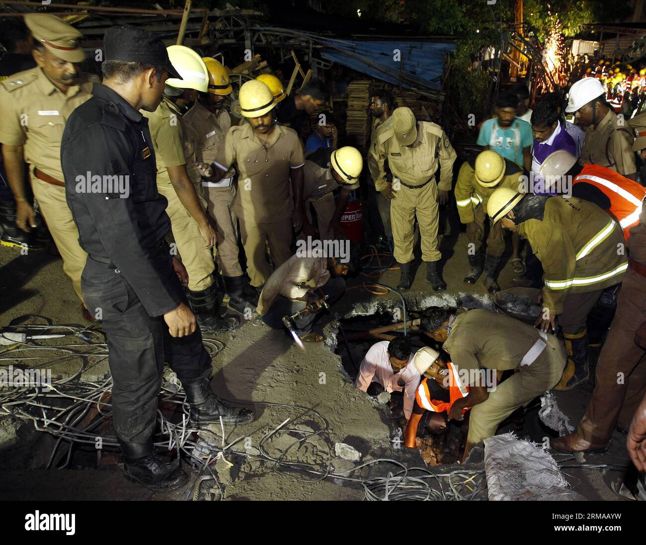 Rescuers search for workers buried in the rubbles of a building that ...