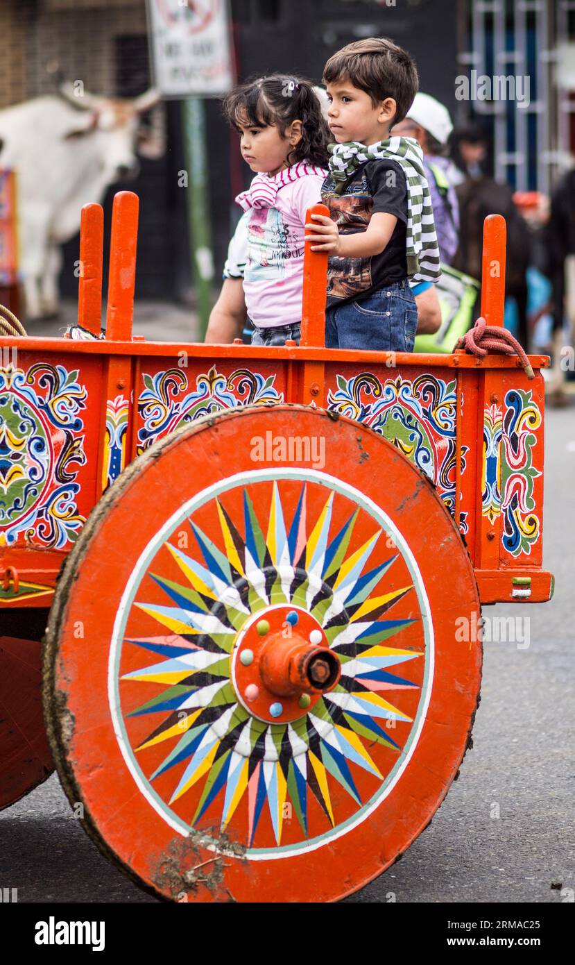 Young boy and girl riding in a colorful hand painted ox cart in a ...