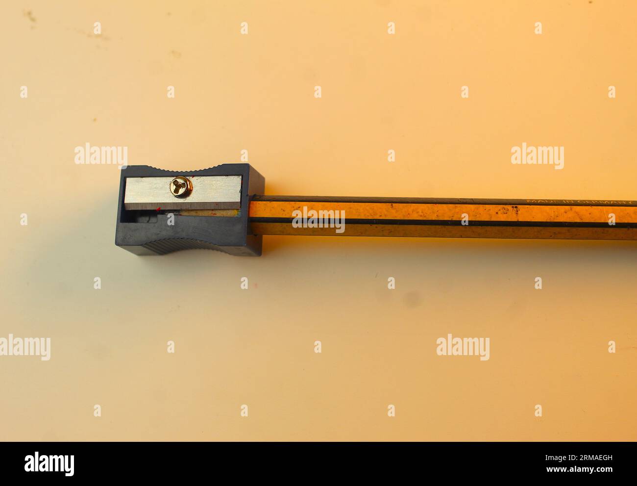 A photo of a pencil in a small sharpener on a desk Stock Photo - Alamy