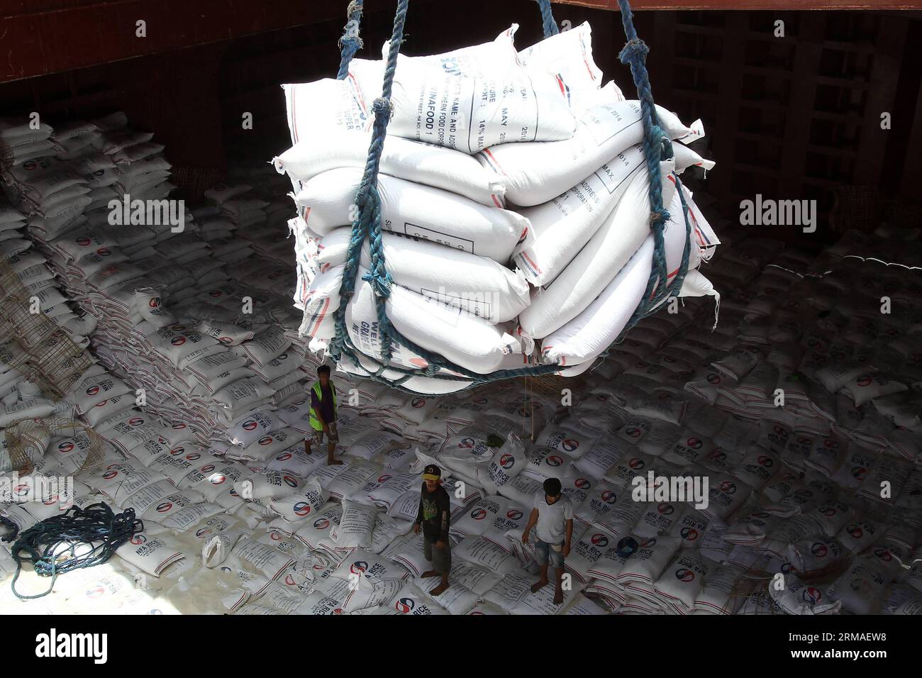 (140705) -- MANILA, July 5, 2014 (Xinhua) -- Workers unload sacks of ...