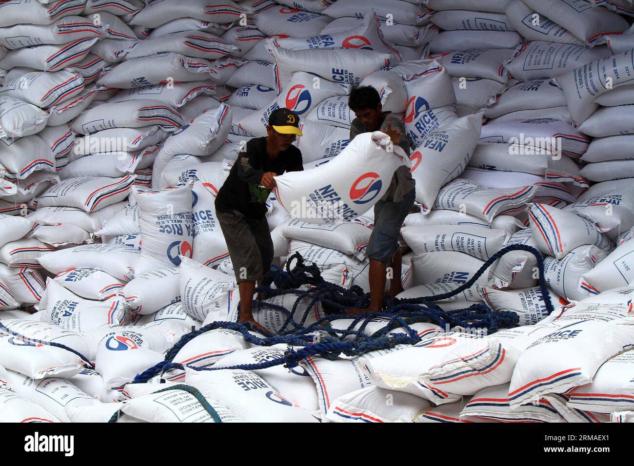 (140705) -- MANILA, July 5, 2014 (Xinhua) -- Workers unload sacks of ...