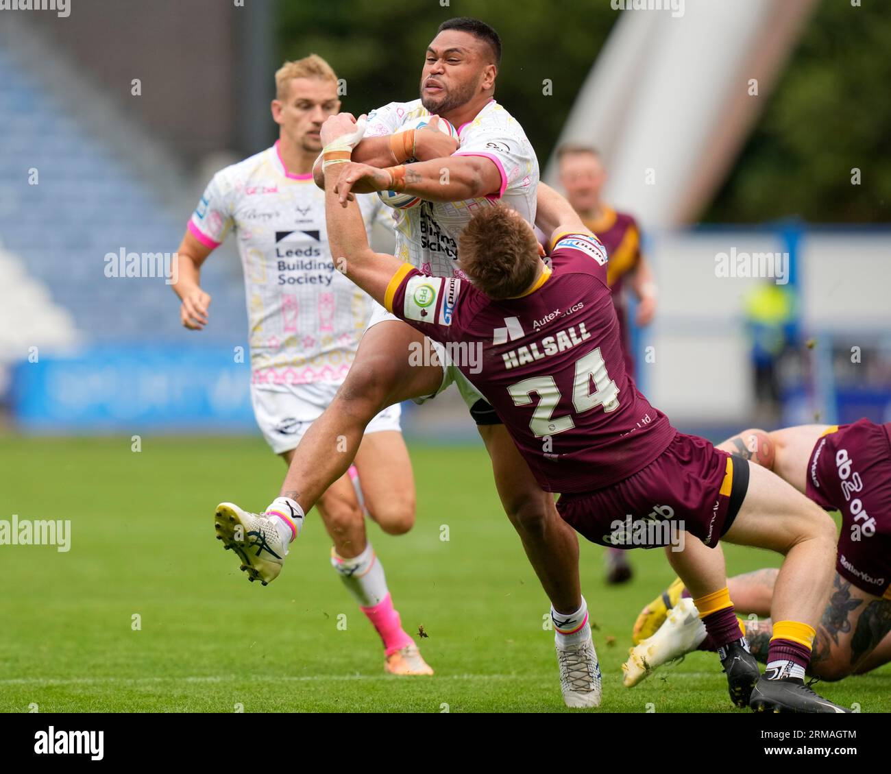 Sam Halsall #24 of Huddersfield Giants attempts to tackle Sam Lisone ...