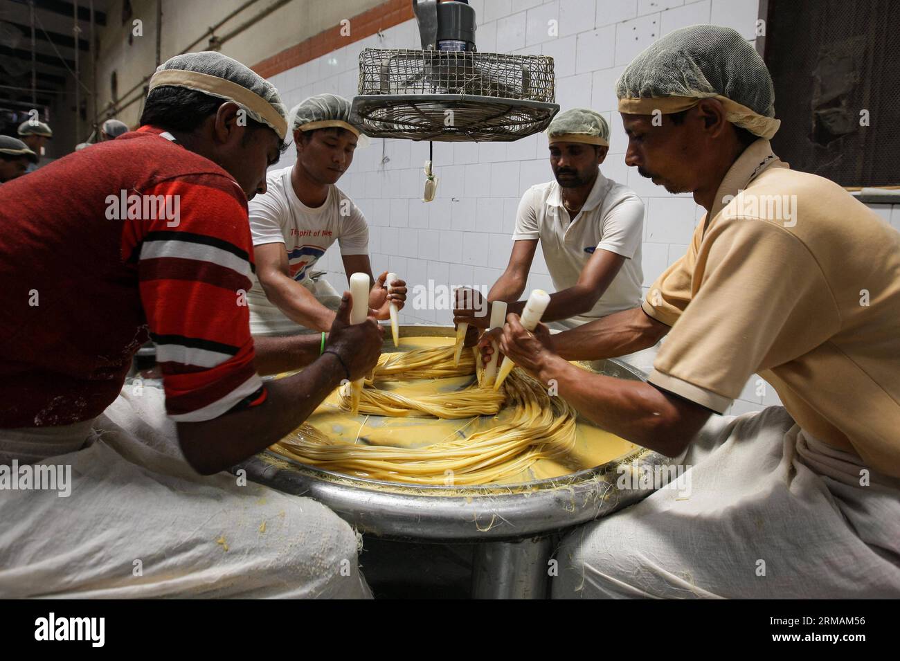 BIKANER, July 15, 2014 (Xinhua) -- Workers make sweets at the snack ...