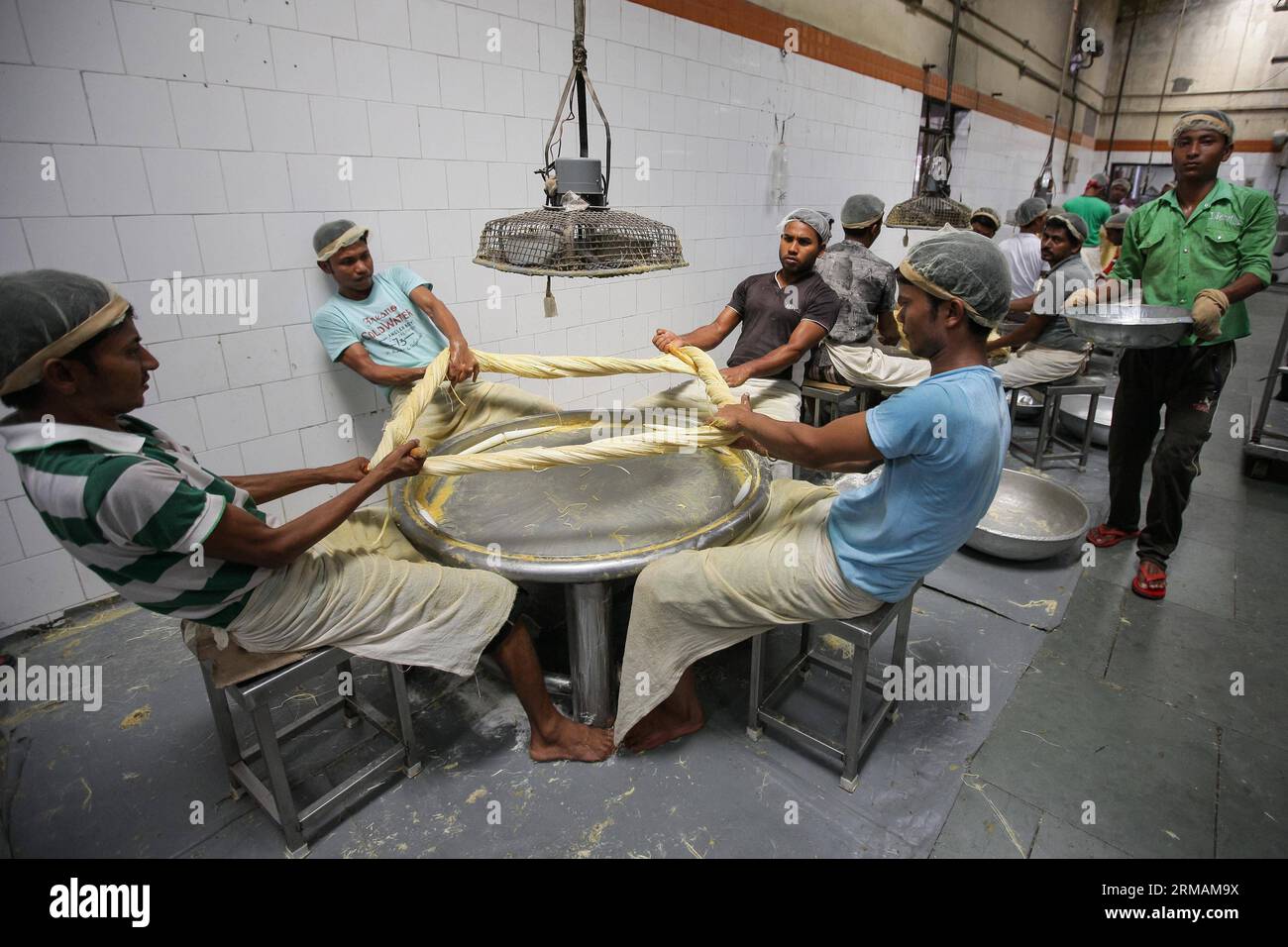 BIKANER, July 15, 2014 (Xinhua) -- Workers make sweets at the snack ...