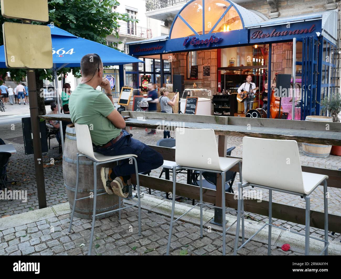 Man enjoying a live music performance outside a bar in Morlaix ...