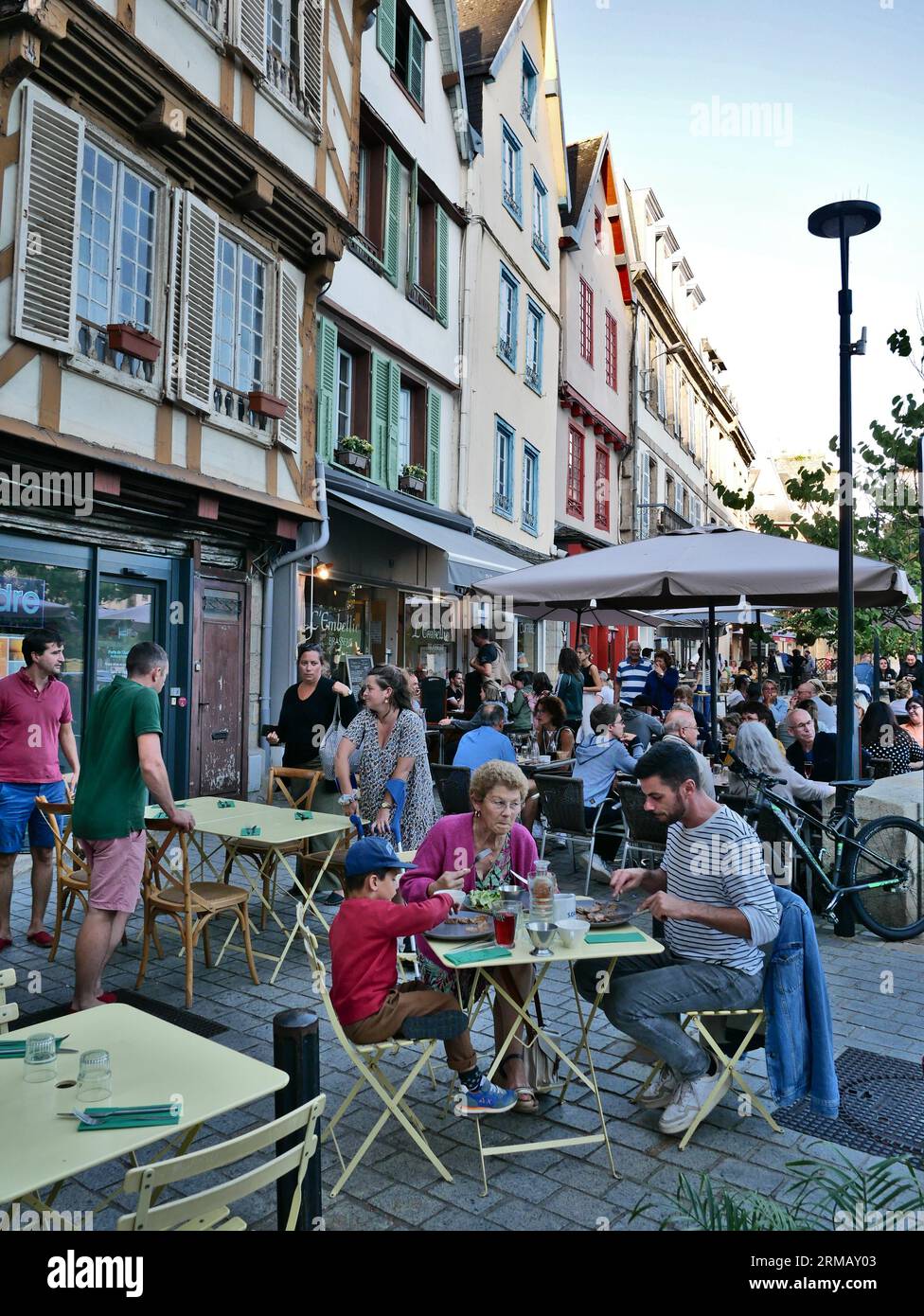 People eating dinner at tables outside restaurants in Morlaix, Brittany ...