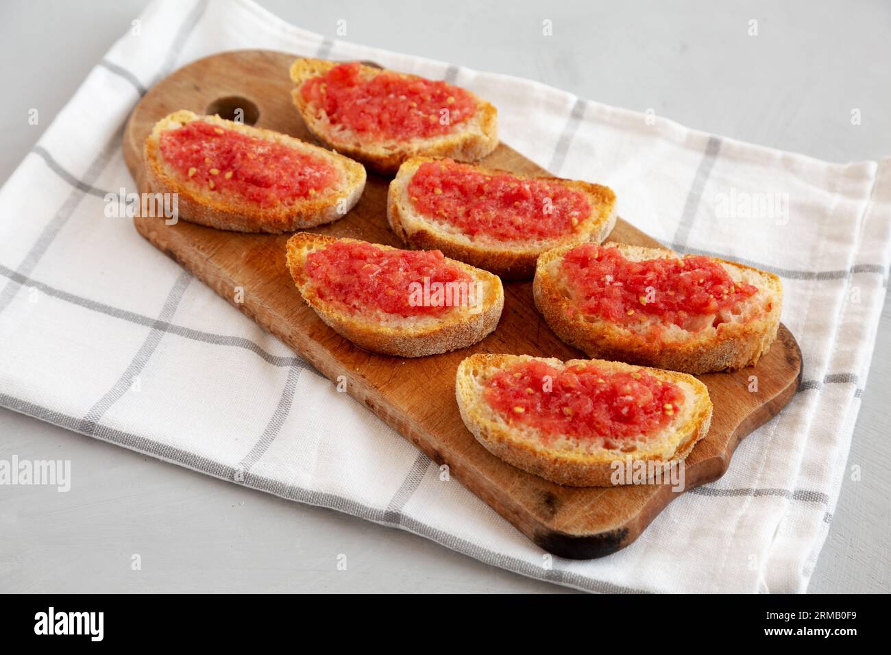 Homemade Pan Con Tomate (Tomato Toast) on a Rustic Wooden Board, side ...