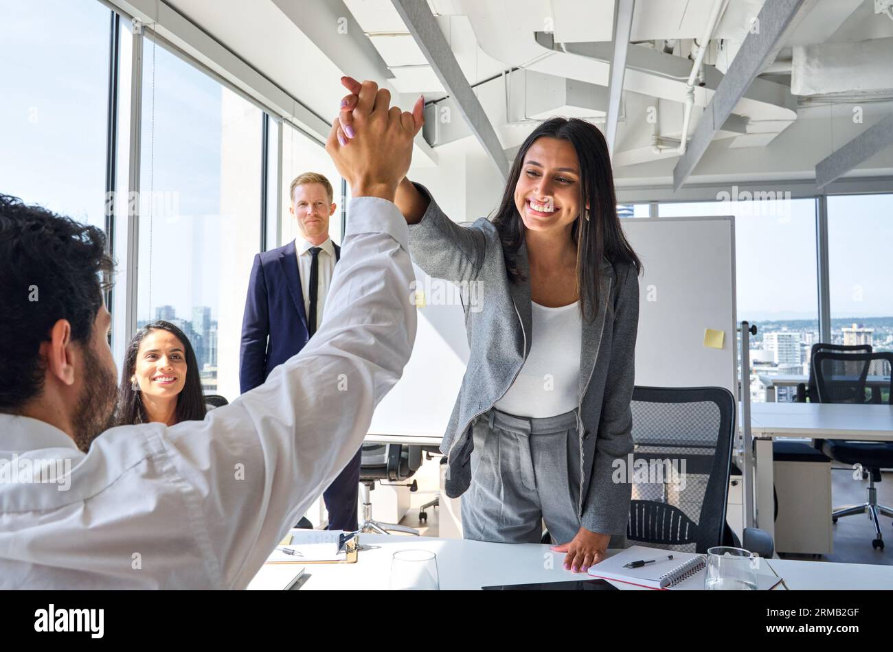 Happy Indian woman worker giving male colleague high five at office ...