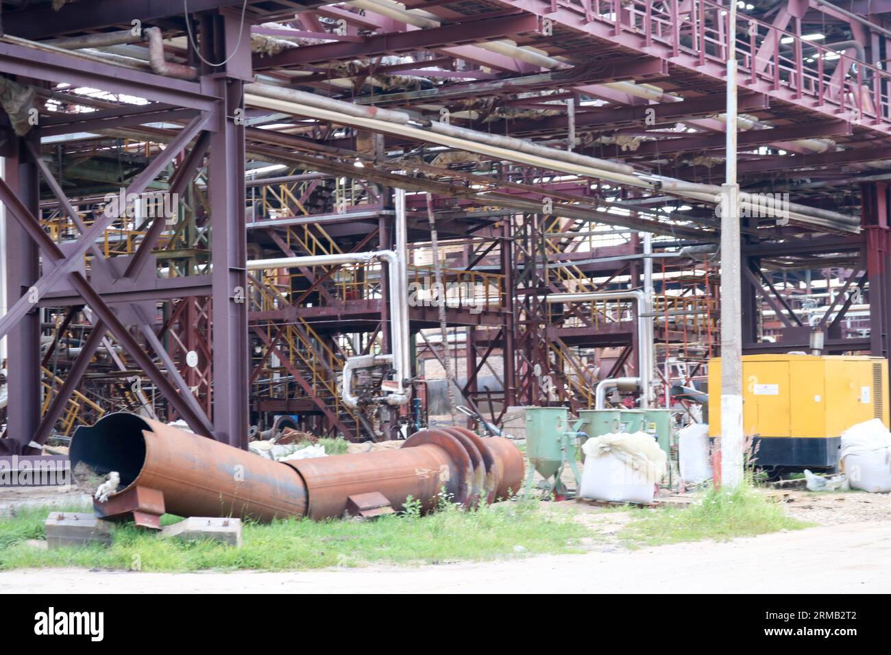 A large iron metal piping trestle with pipes and electric wires and ...