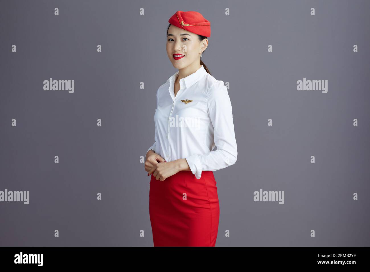 smiling modern asian female stewardess in red skirt and hat uniform ...
