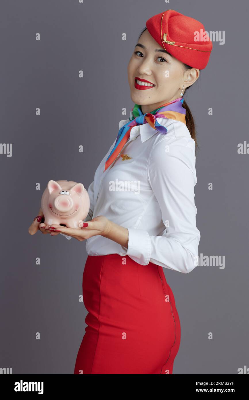 smiling modern asian female stewardess in red skirt and hat uniform ...