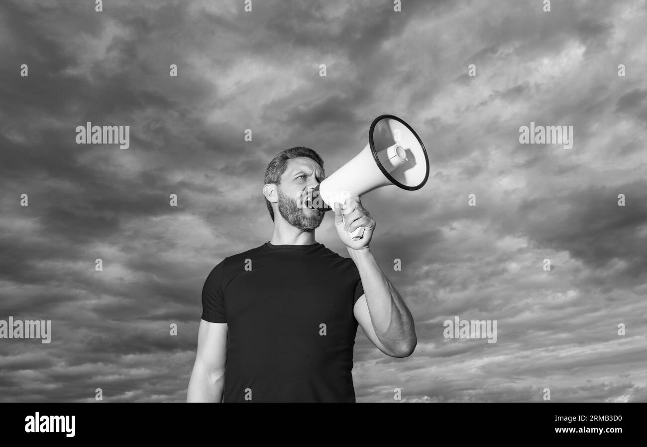man in red shirt shout in loudspeaker on sky background. attention ...