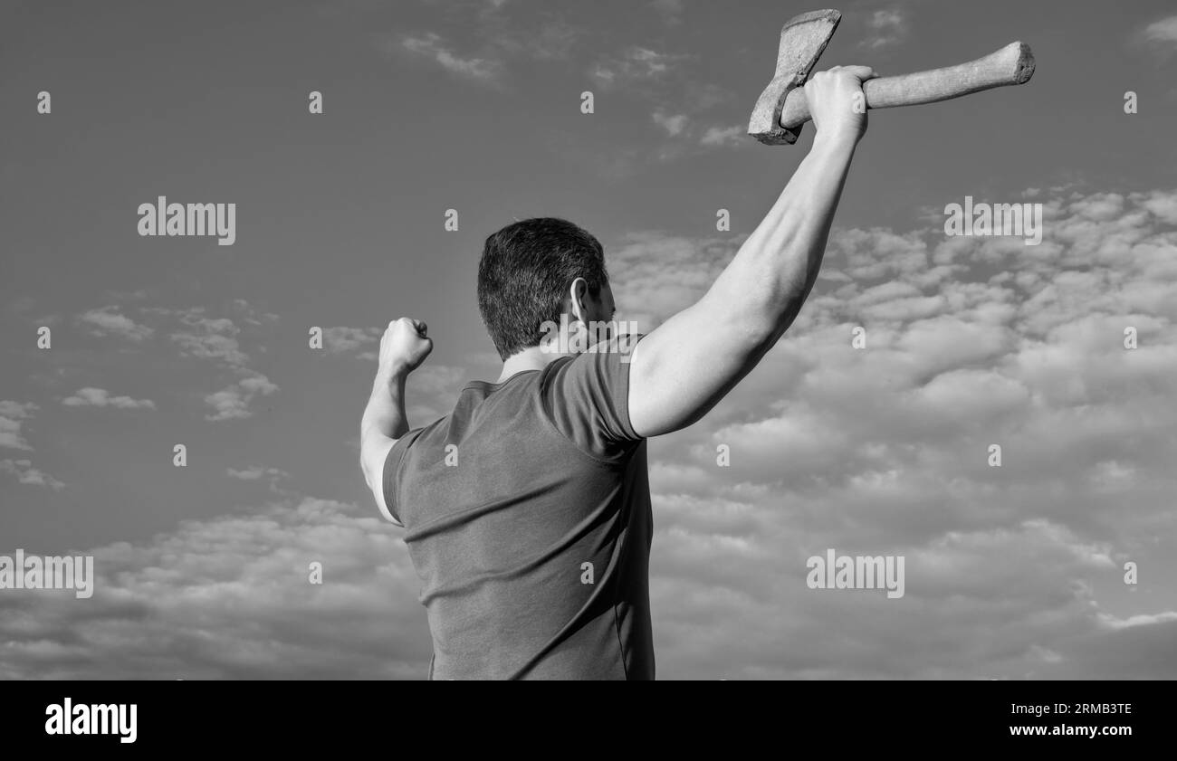 back view of free man with axe. man hold ax. brutal man on sky ...