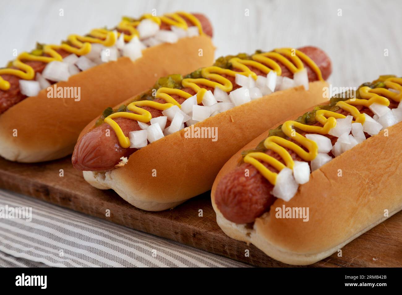 Char Grilled Hot Dog with Mustard, Relish and Onion on a rustic wooden ...