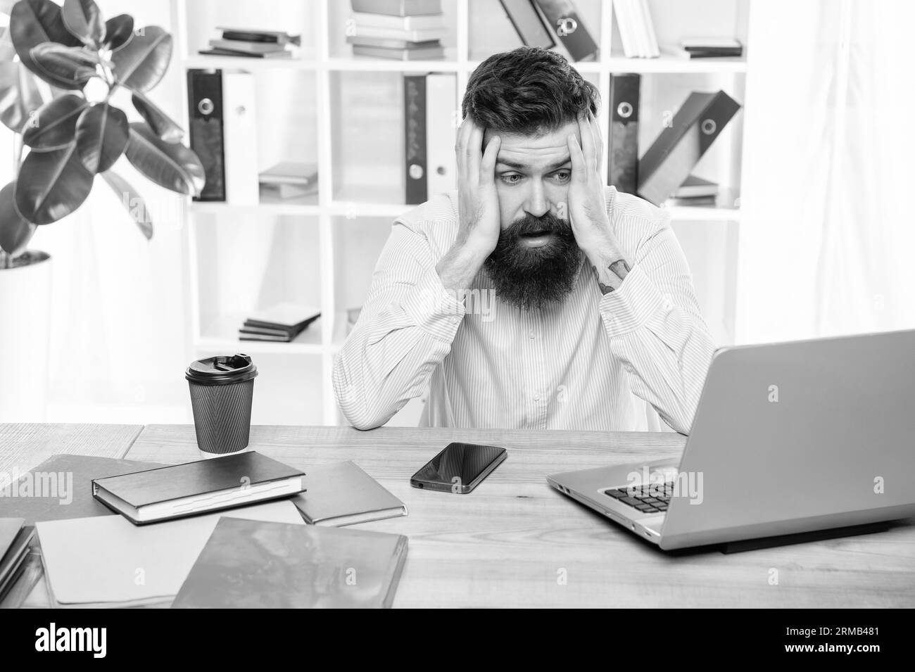 Frustated businessman clutching head looking at work computer in office ...
