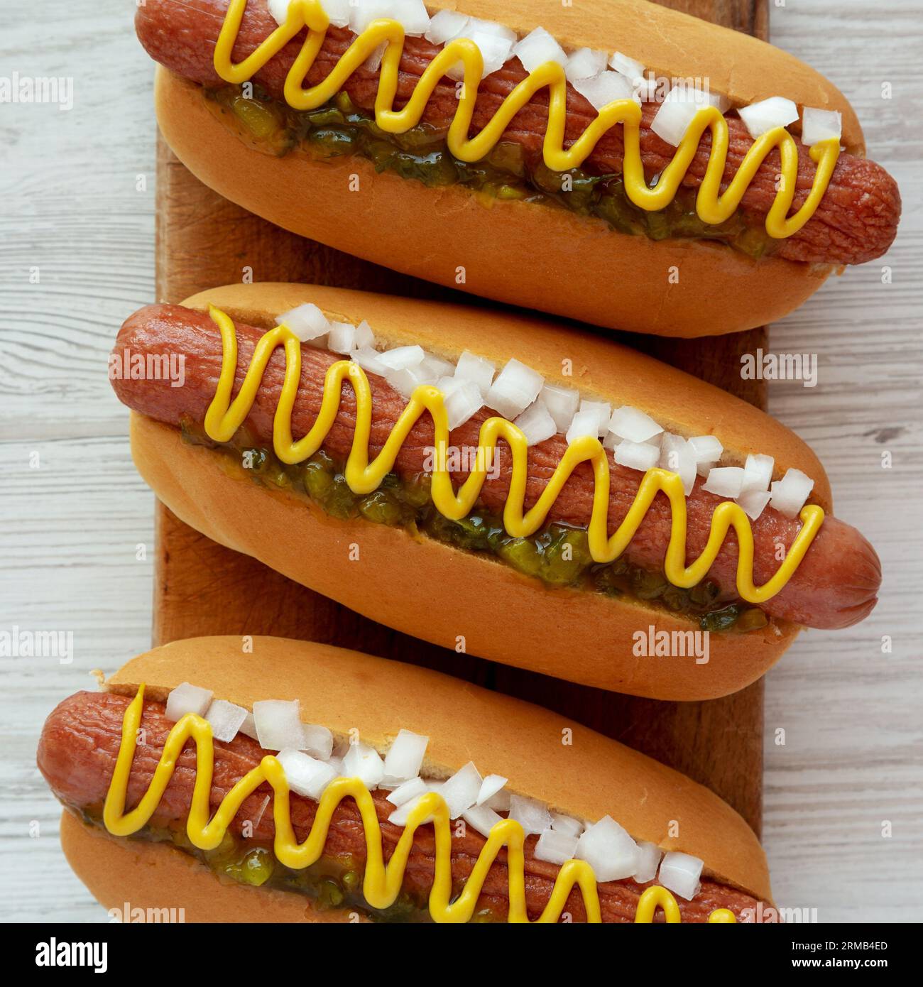 Char Grilled Hot Dog with Mustard, Relish and Onion on a rustic wooden ...