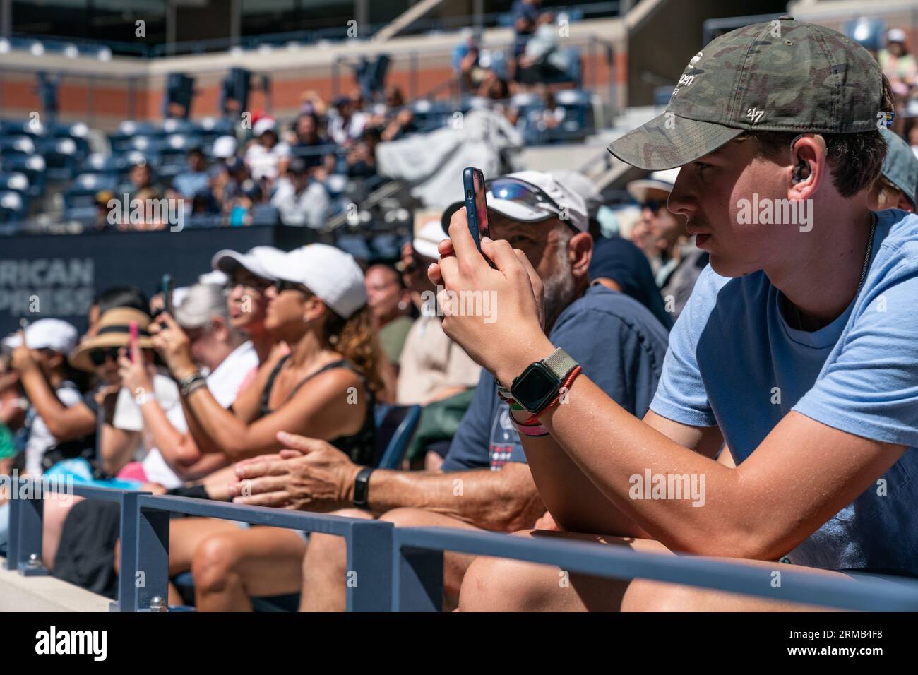 Fans watching and taking photos and videos of practice on Ashe Stadium ...
