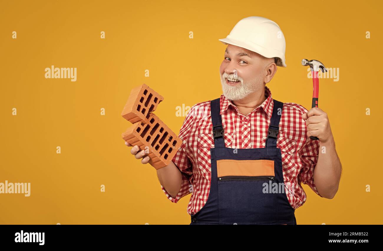 happy old man worker in helmet on yellow background Stock Photo - Alamy