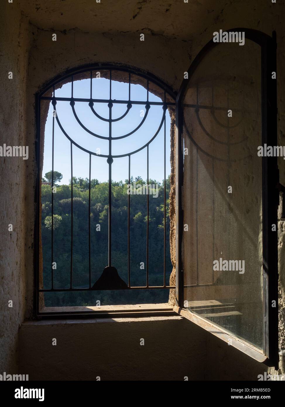 Looking out a window with a menorah iron grilles in Pitigliano Jewish ...