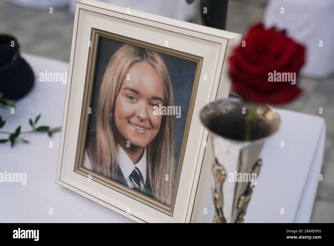 A picture of Nicole Murphy on display as people light candles at the ...
