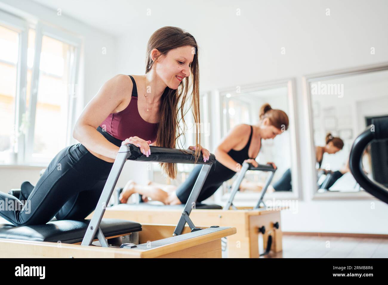 Two young females doing ABS muscles strength exercises using pilates ...