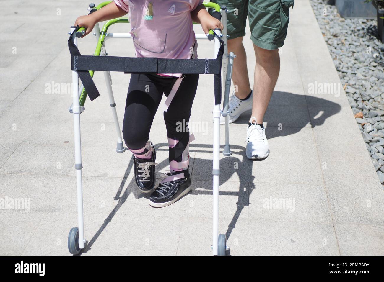 child with walking frame and knee orthosis outdoor Stock Photo - Alamy