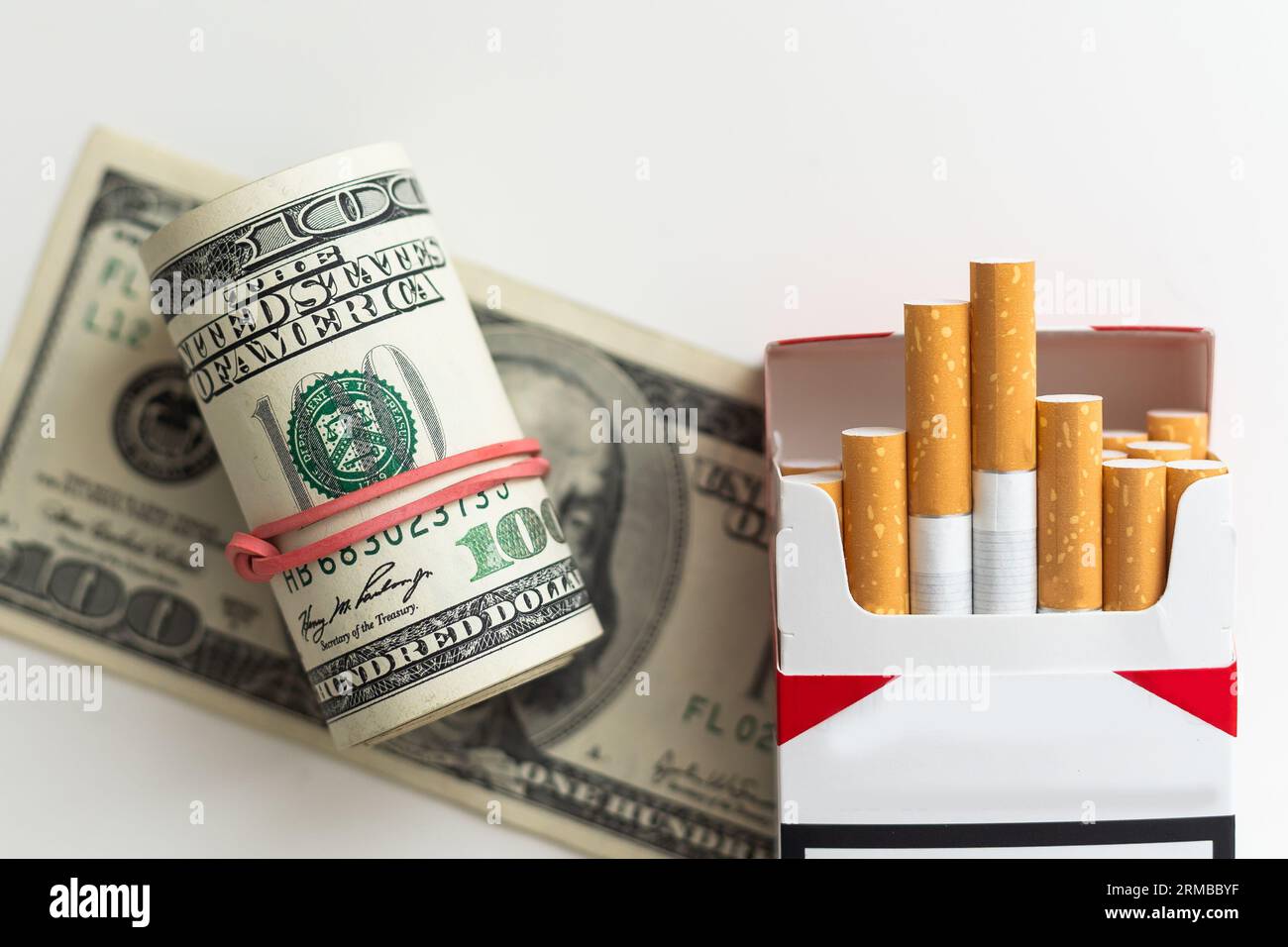 cigarettes and money. expensive habit. white background - horizontal ...