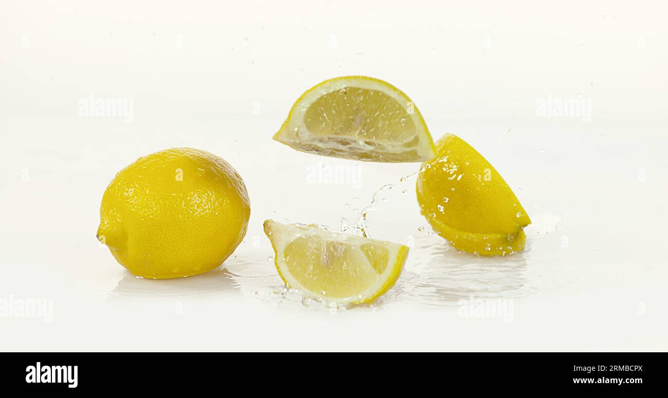 Yellow Lemons, citrus limonum, Fruits Rolling on Water and splashing ...