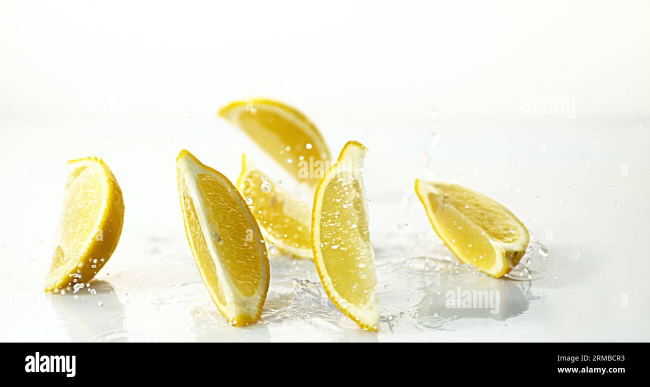 Yellow Lemons, citrus limonum, Fruits Rolling on Water and splashing ...