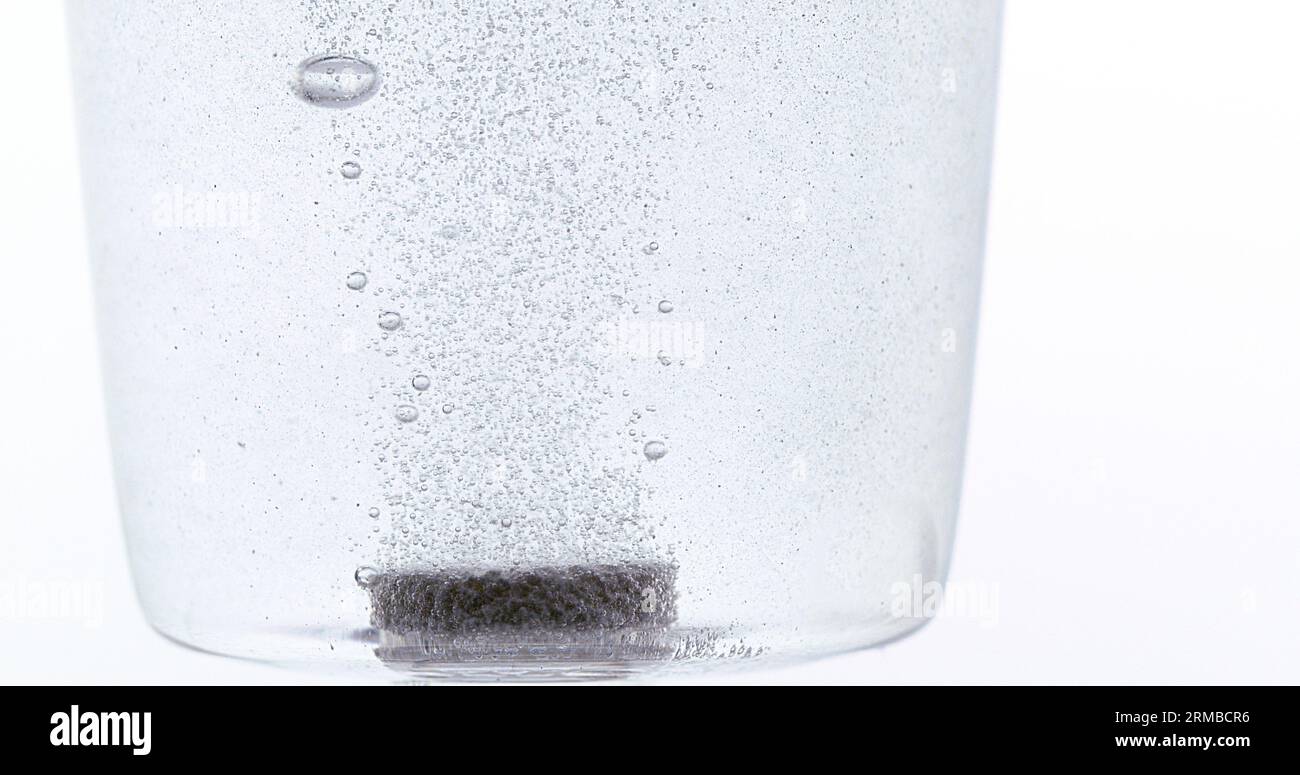 Tablets Falling and Dissolving into a Glass of Water against White ...