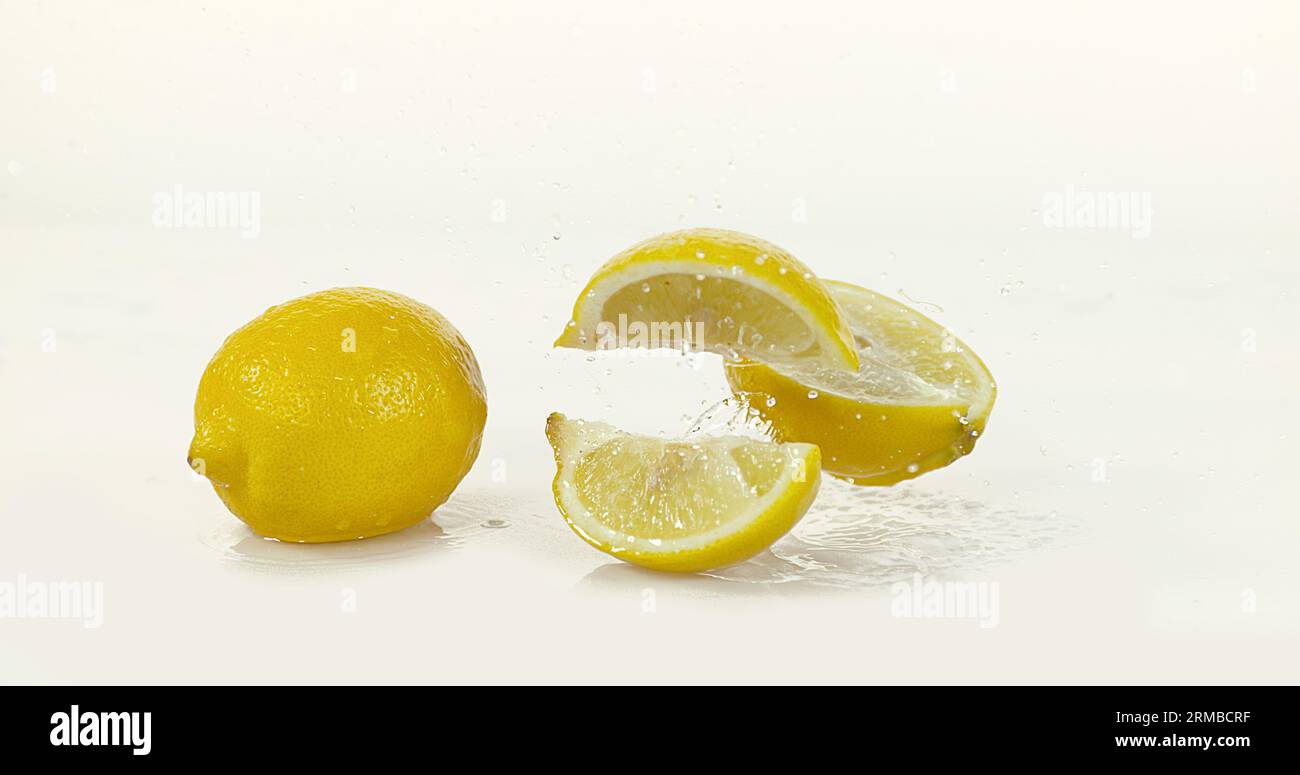 Yellow Lemons, citrus limonum, Fruits Rolling on Water and splashing ...