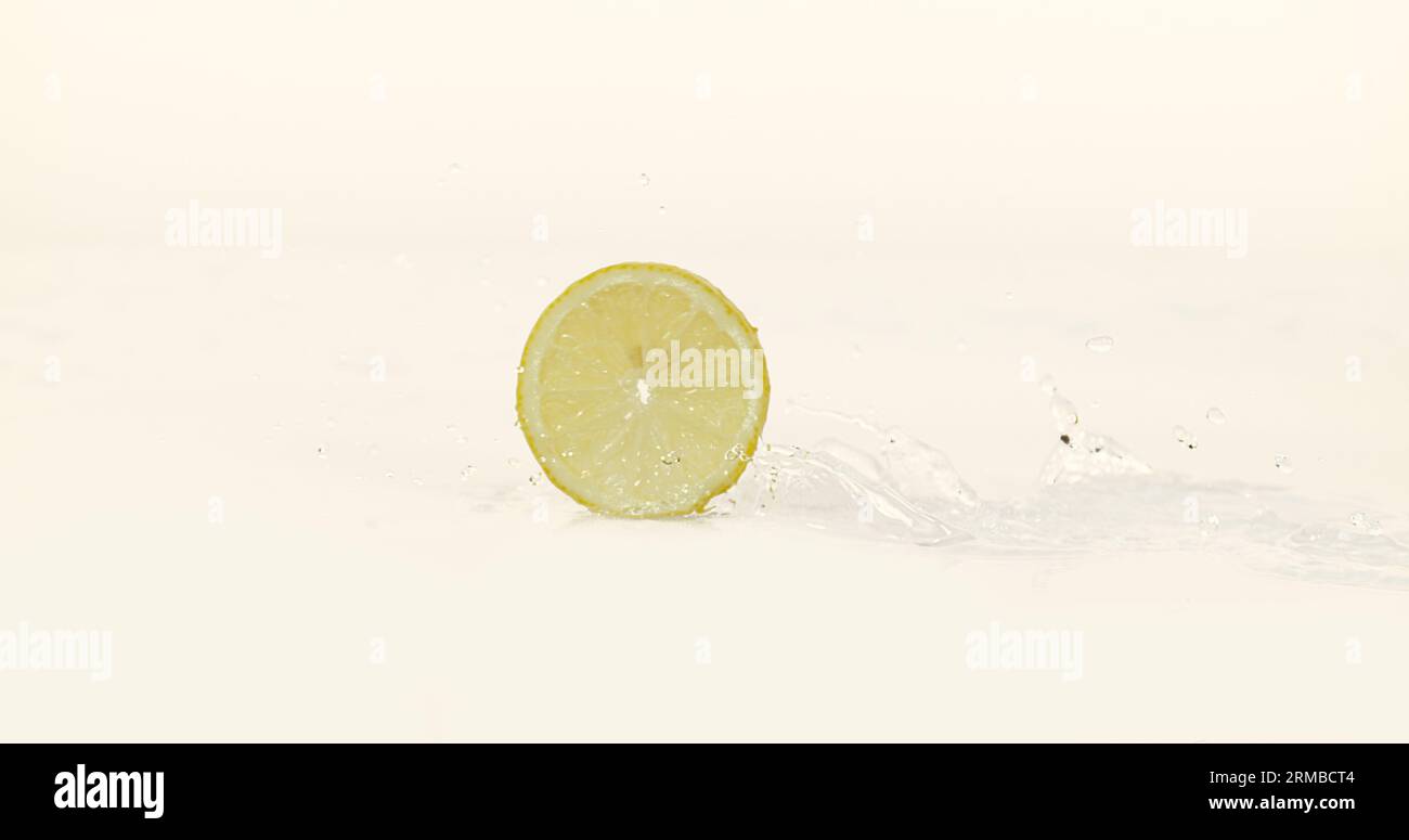 Yellow Lemons, citrus limonum, Fruits Rolling on Water and splashing ...