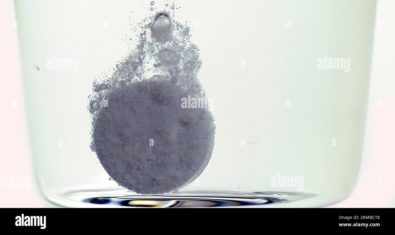 Tablets Falling and Dissolving into a Glass of Water against White ...