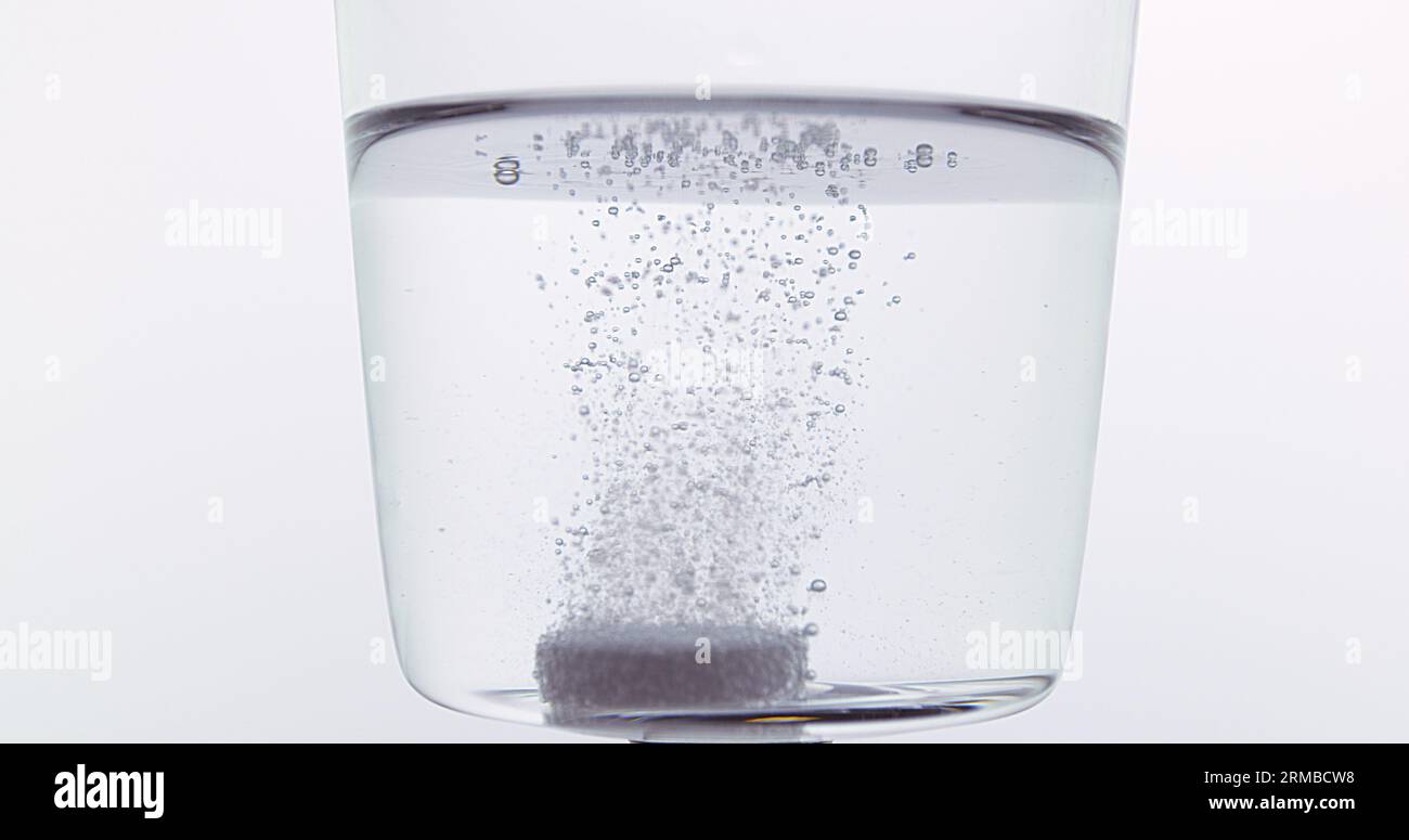 Tablets Falling and Dissolving into a Glass of Water against White ...
