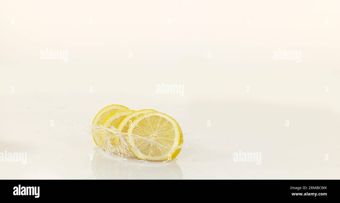 Yellow Lemons, citrus limonum, Fruits Rolling on Water and splashing ...