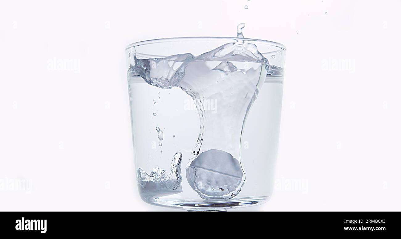 Tablets Falling and Dissolving into a Glass of Water against White ...