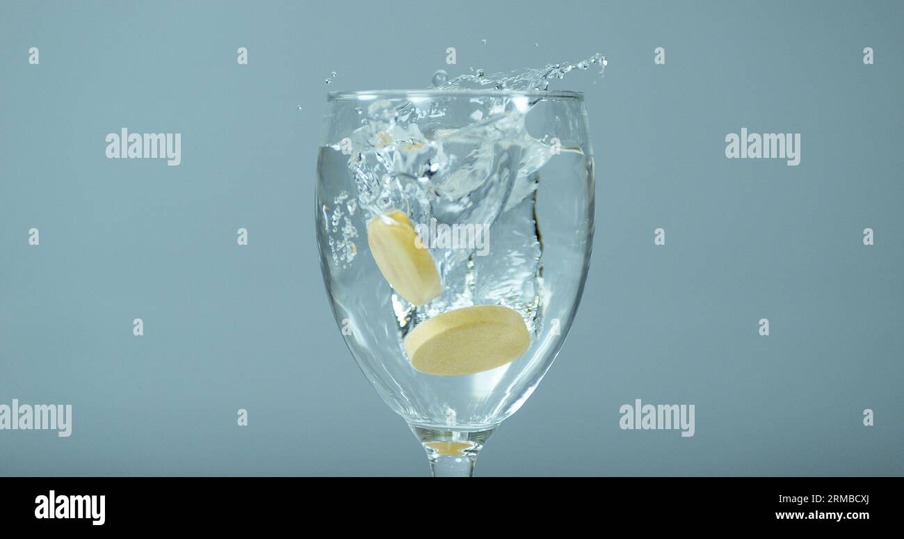 Tablets Falling and Dissolving into a Glass of Water against White ...