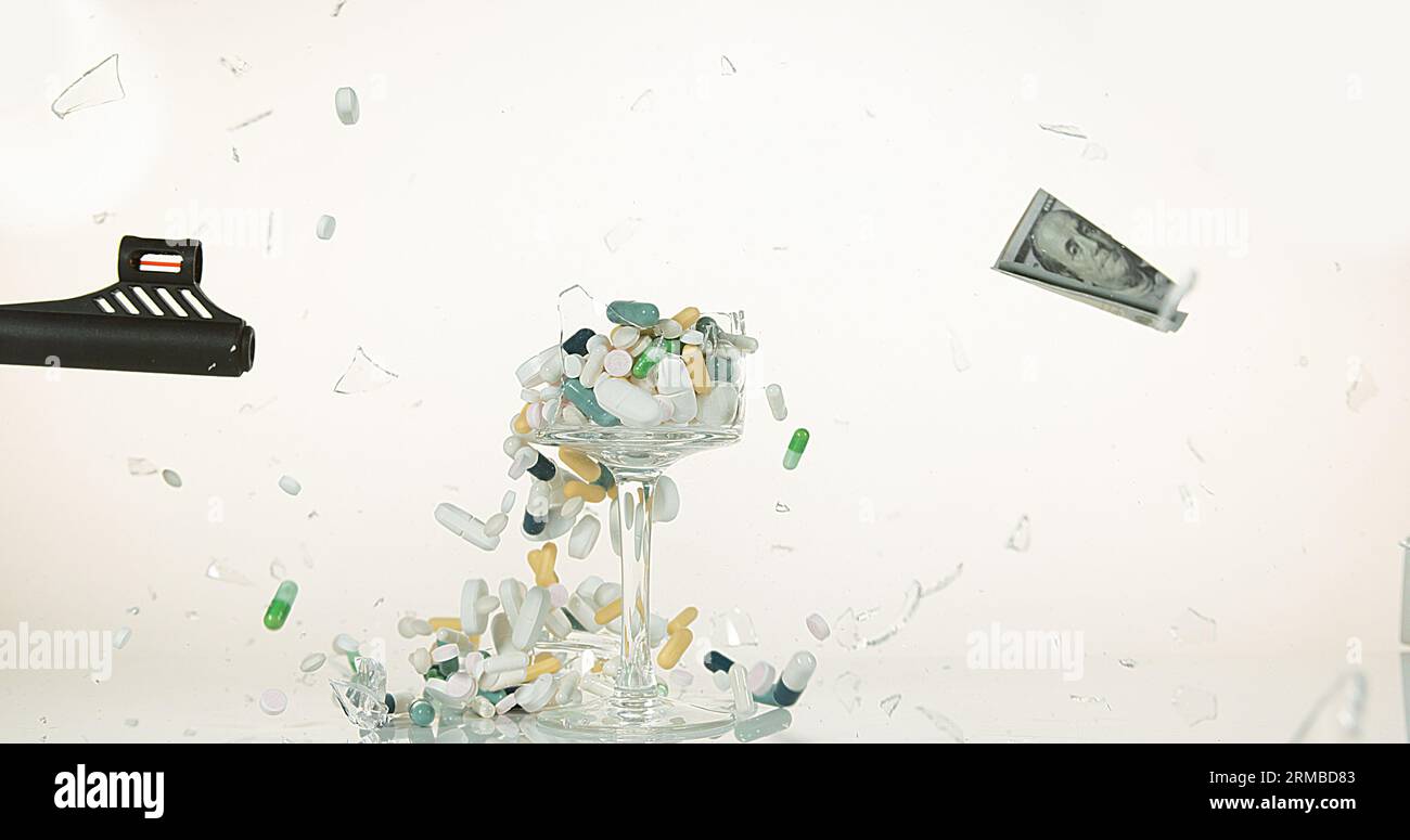Glass filled with Capsules and Dollars Exploding against White ...