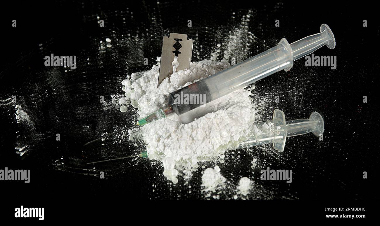 Powder Drug Falling on Razor Blade and Syringes against Black ...