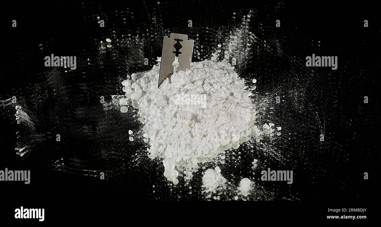 Powder Drug Falling on Razor Blade and Syringes against Black ...
