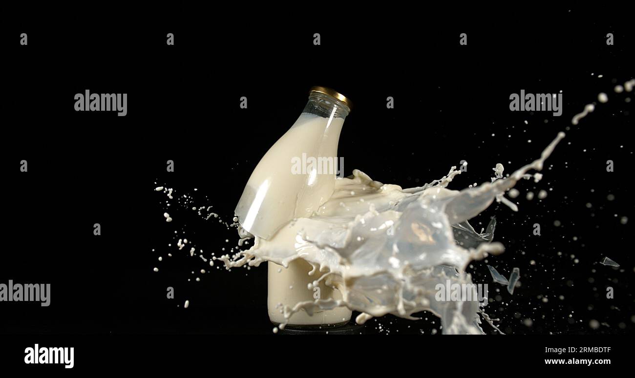 Bottle of Milk Exploding against Black Background Stock Photo - Alamy