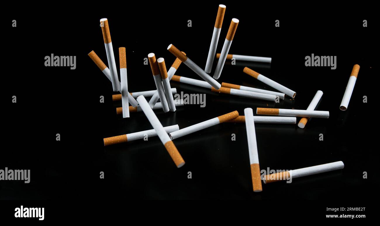 Cigarettes Falling against Black Background Stock Photo - Alamy