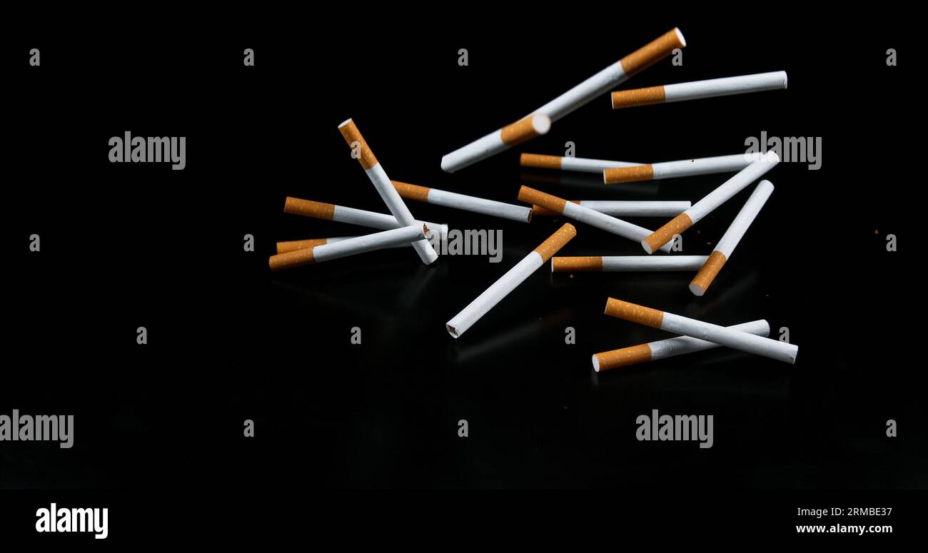 Cigarettes Falling against Black Background Stock Photo - Alamy