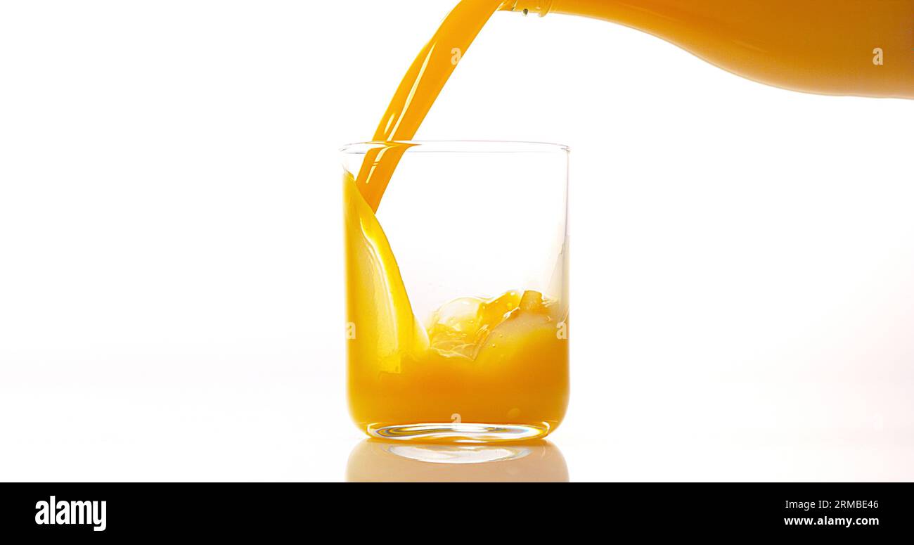 Orange Juice being poured into Glass against White Background Stock ...