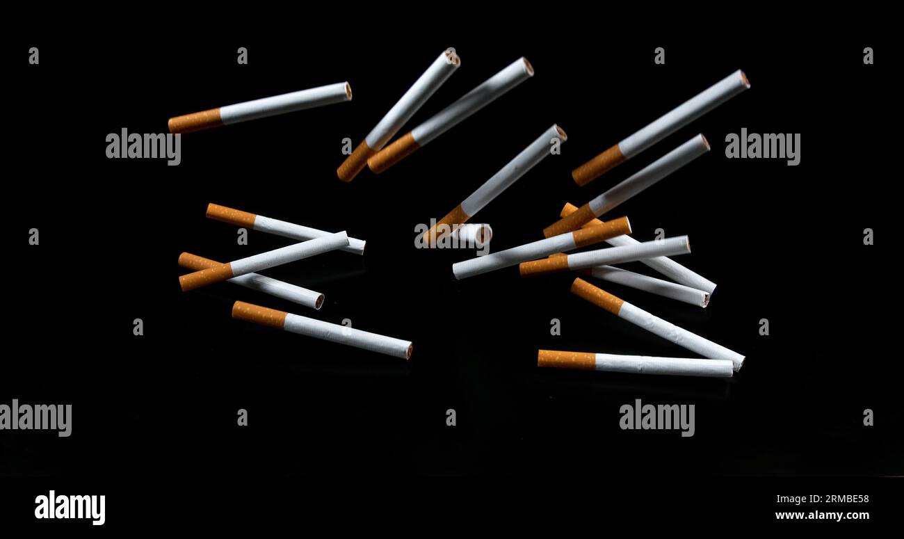 Cigarettes Falling against Black Background Stock Photo - Alamy