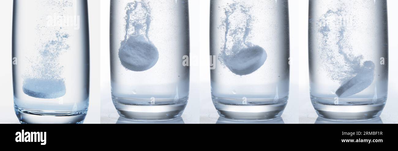 Tablets Falling and Dissolving into a Glass of Water against White ...