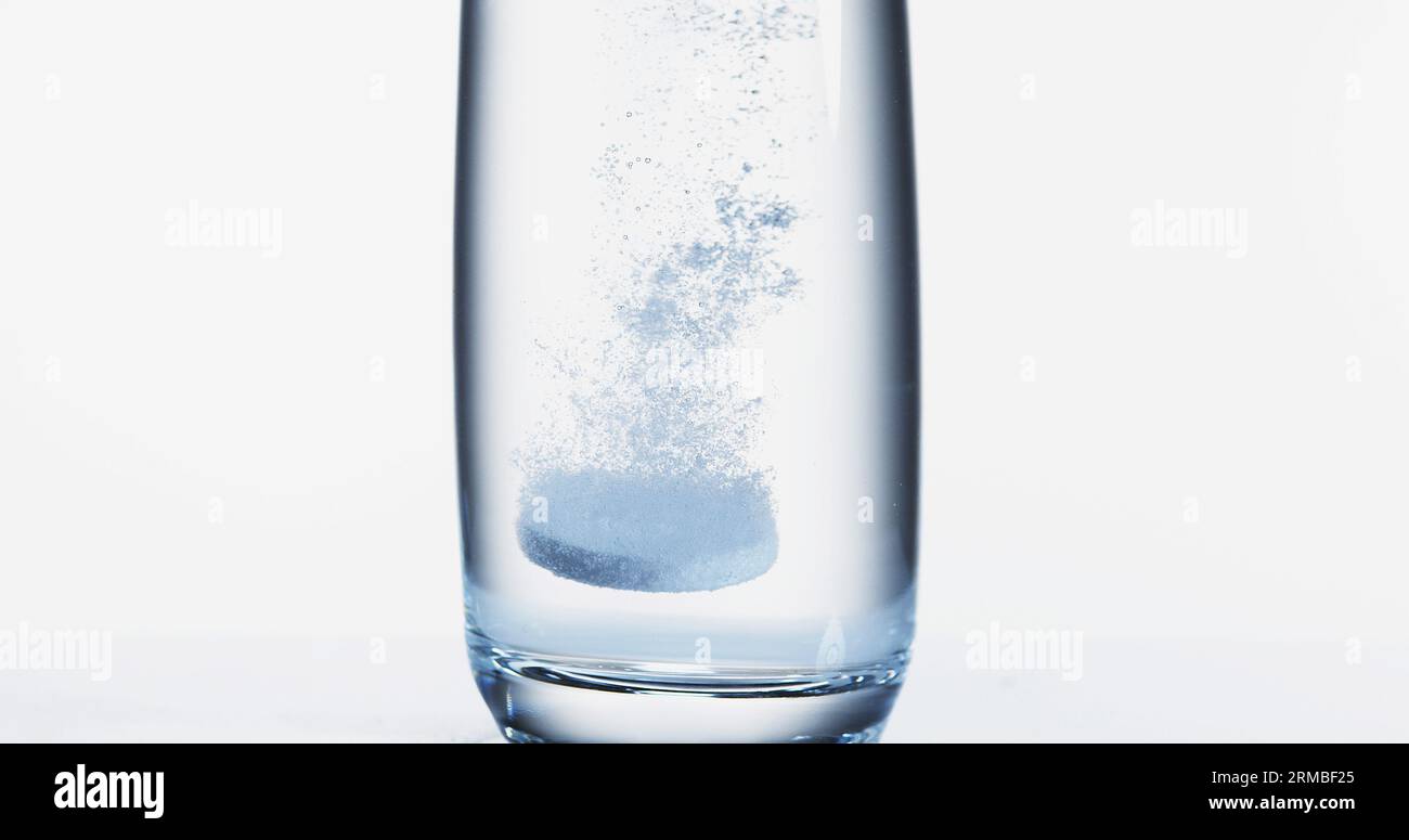 Tablets Falling and Dissolving into a Glass of Water against White ...
